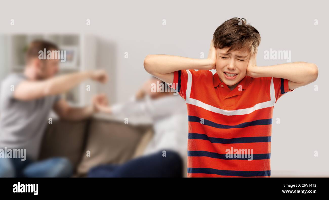 boy closing ears with hands over parents fighting Stock Photo - Alamy