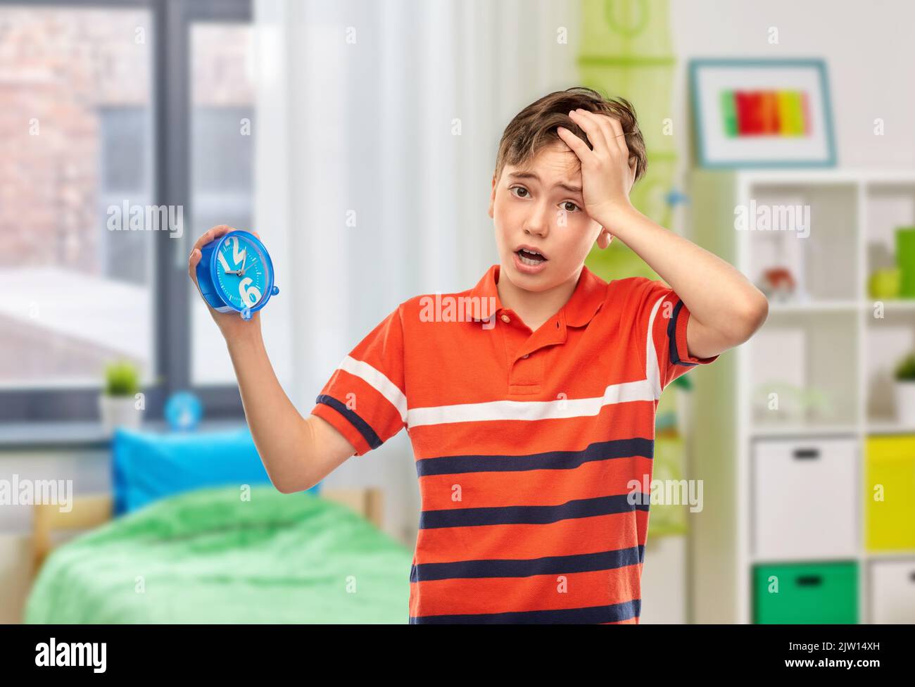 stressed boy with alarm clock at home Stock Photo - Alamy
