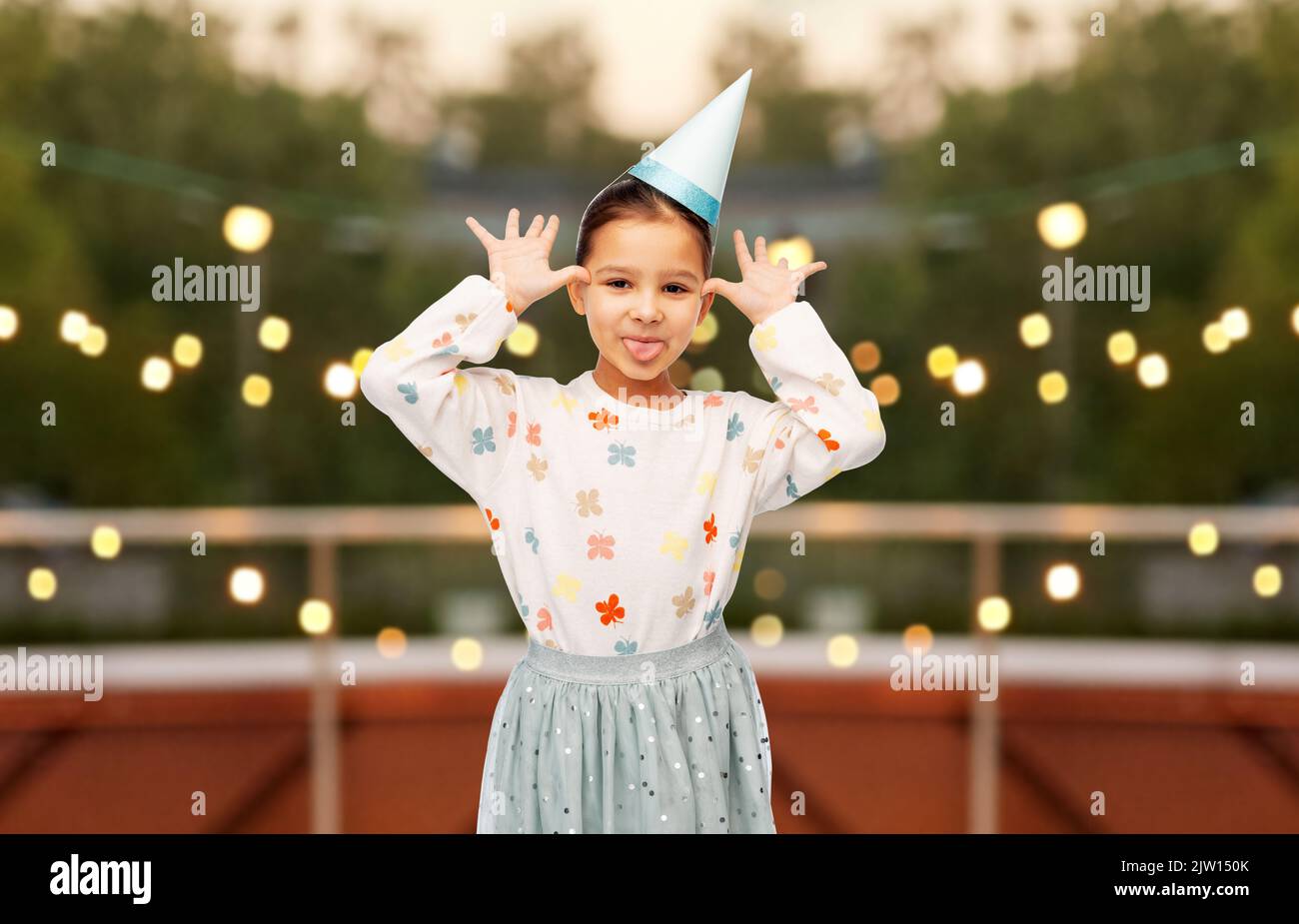 little girl in birthday party hat making faces Stock Photo - Alamy