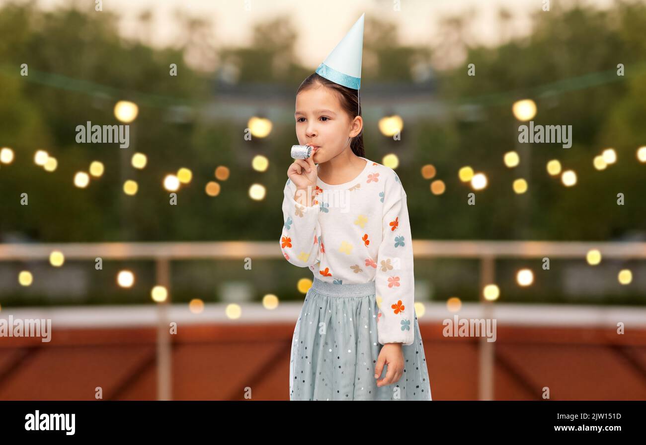 smiling girl in birthday party hat with blower Stock Photo - Alamy