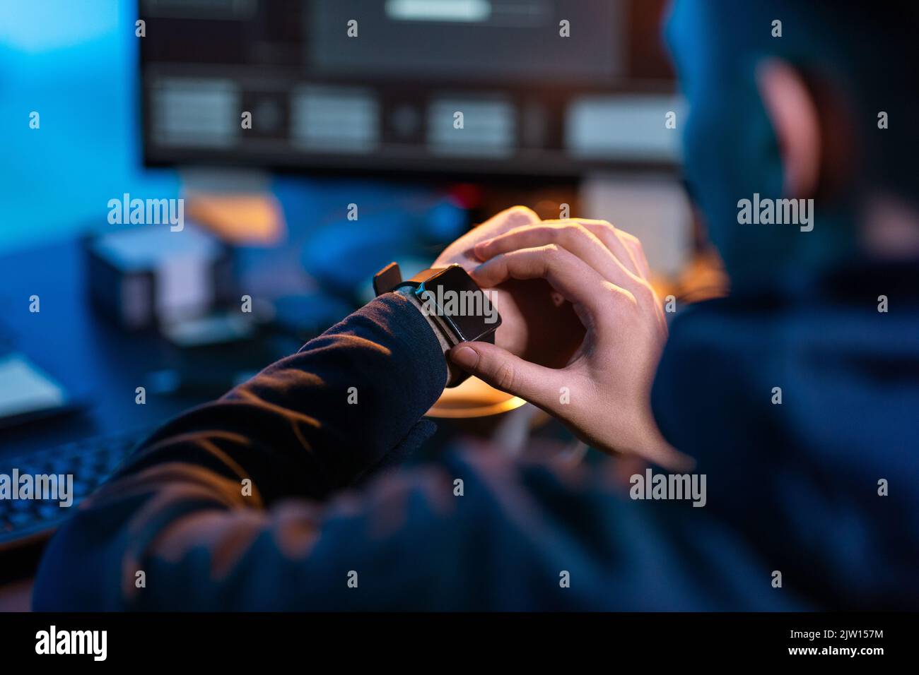 hacker with smart watch and computers in dark room Stock Photo - Alamy