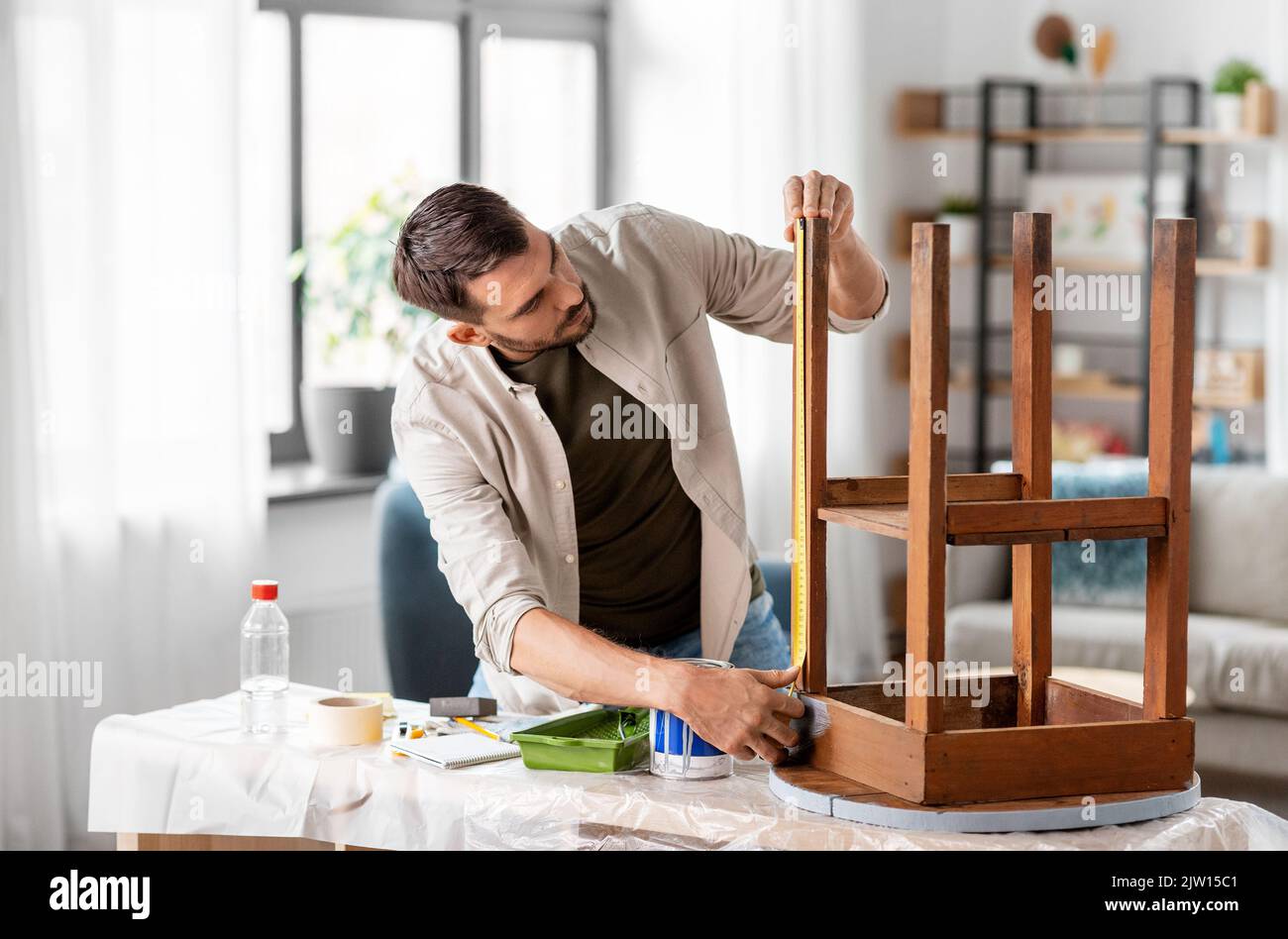 man with ruler measuring table for renovation Stock Photo - Alamy