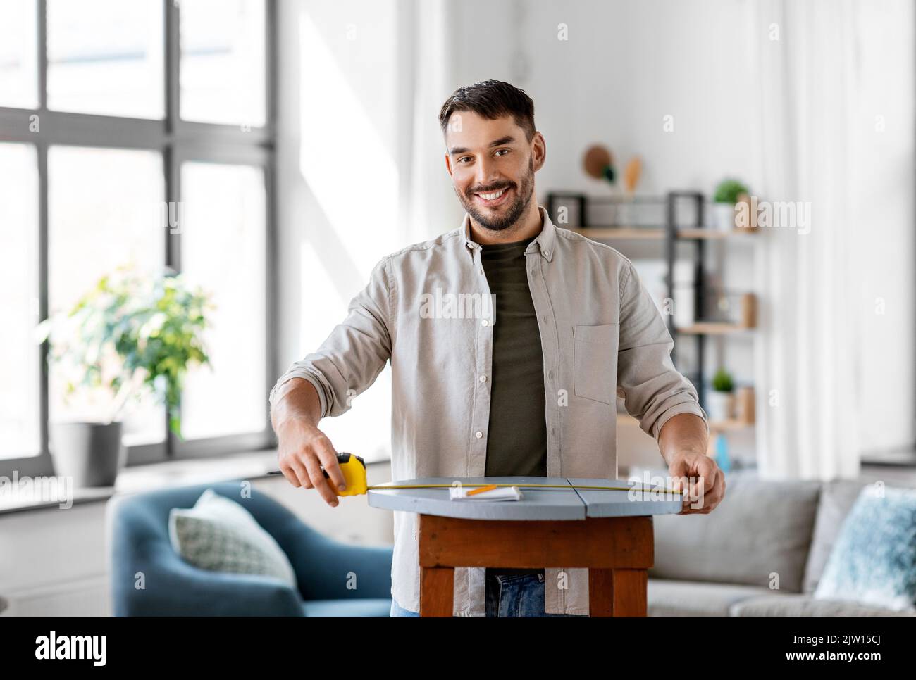 man with ruler measuring table for renovation Stock Photo - Alamy
