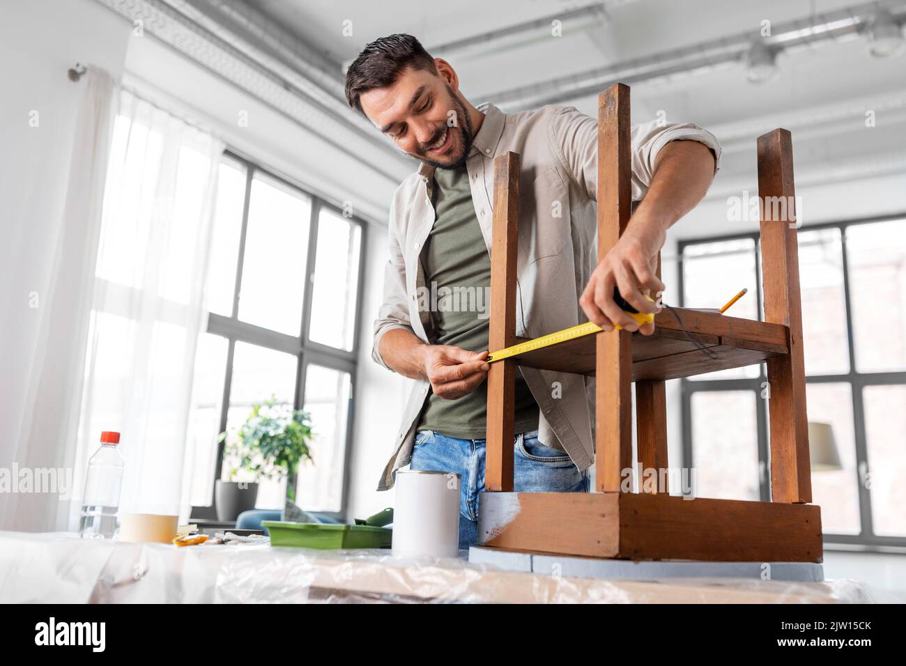 man with ruler measuring table for renovation Stock Photo - Alamy