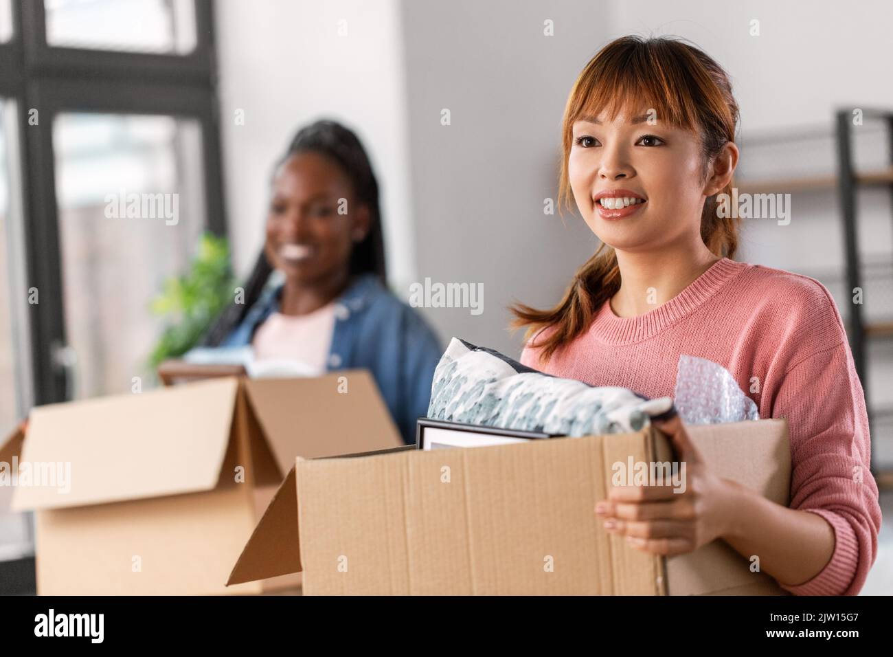 women with boxes moving to new home Stock Photo - Alamy