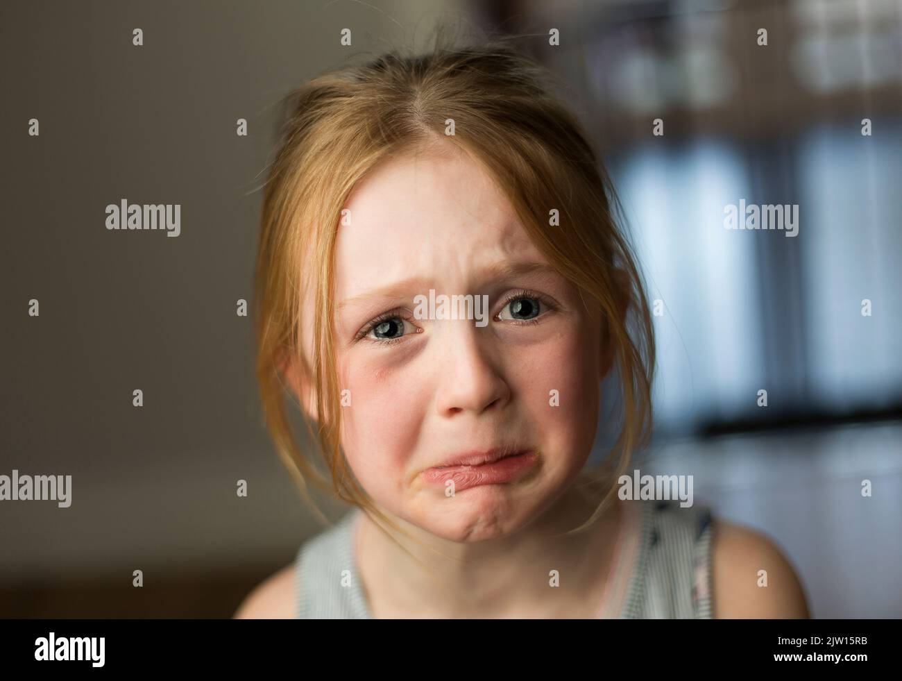 Caucasian young female looks into camera with a very upset expression ...