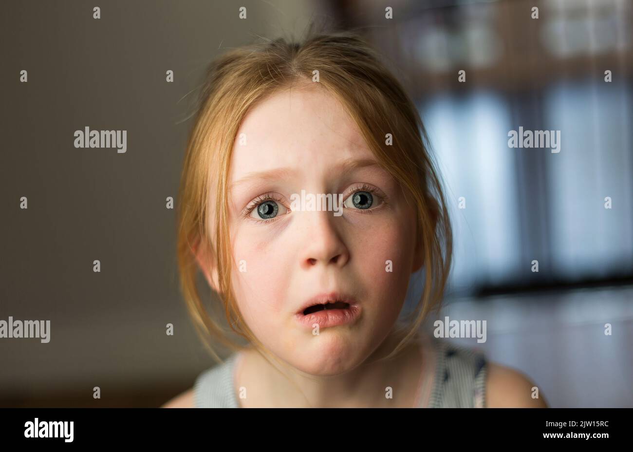 Young Caucasian female looks into camera with an unhappy expression ...