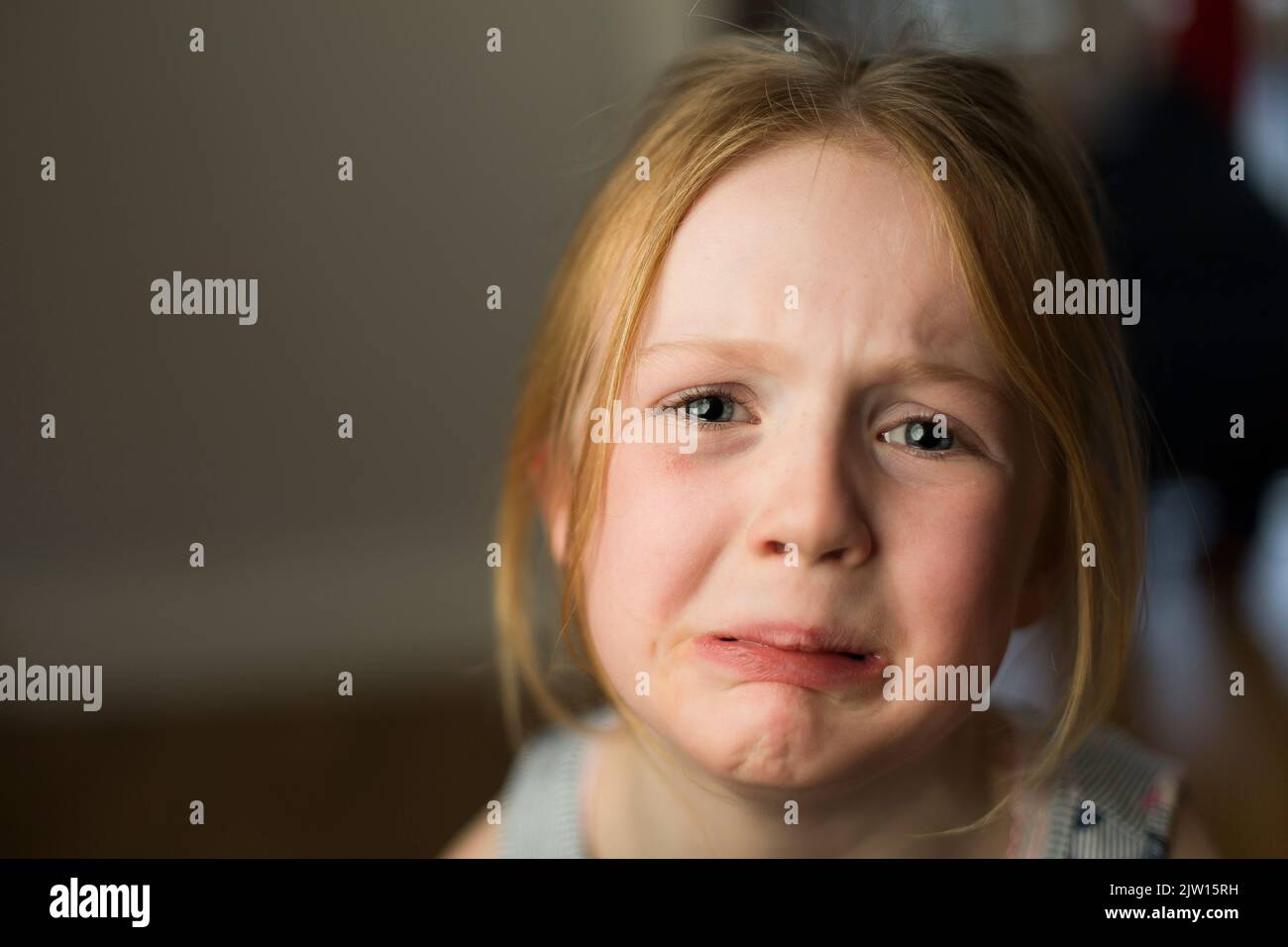 Caucasian young female looks into camera with a very upset expression ...