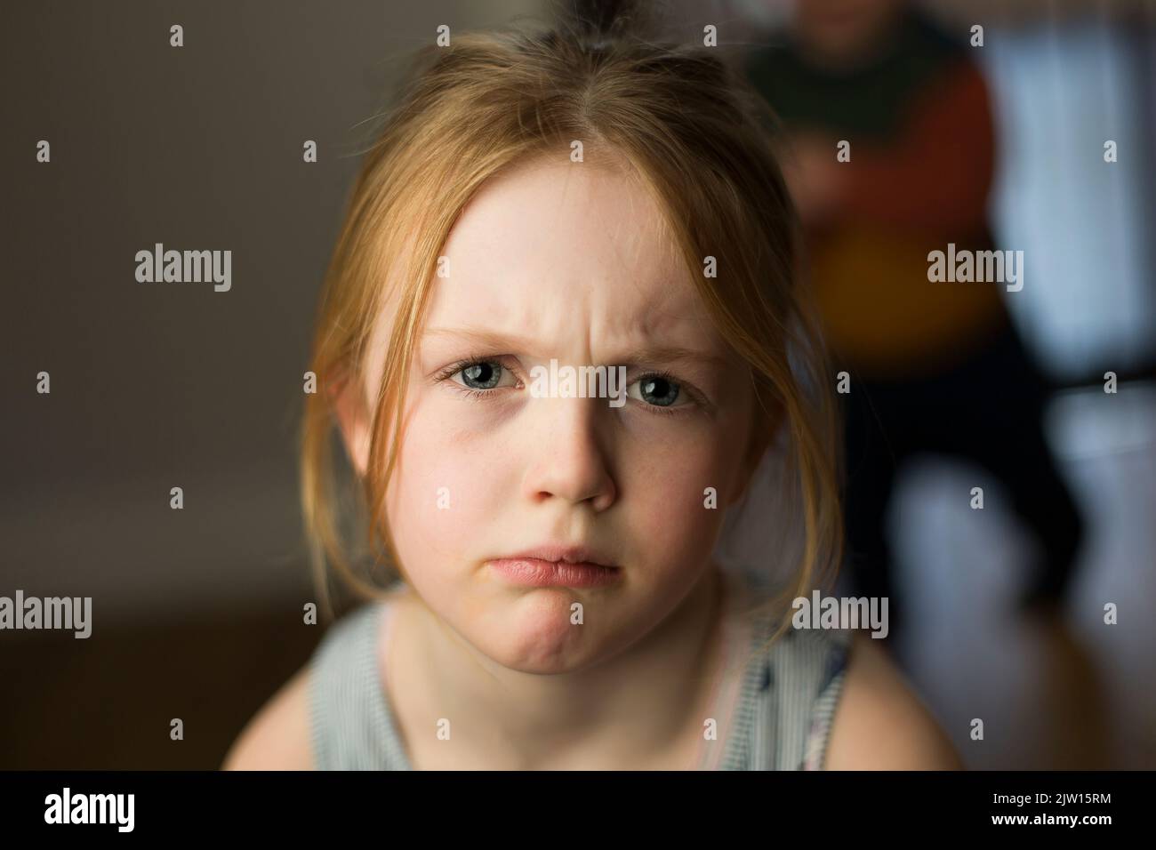 Young Caucasian female looks into camera with a angry frowning ...