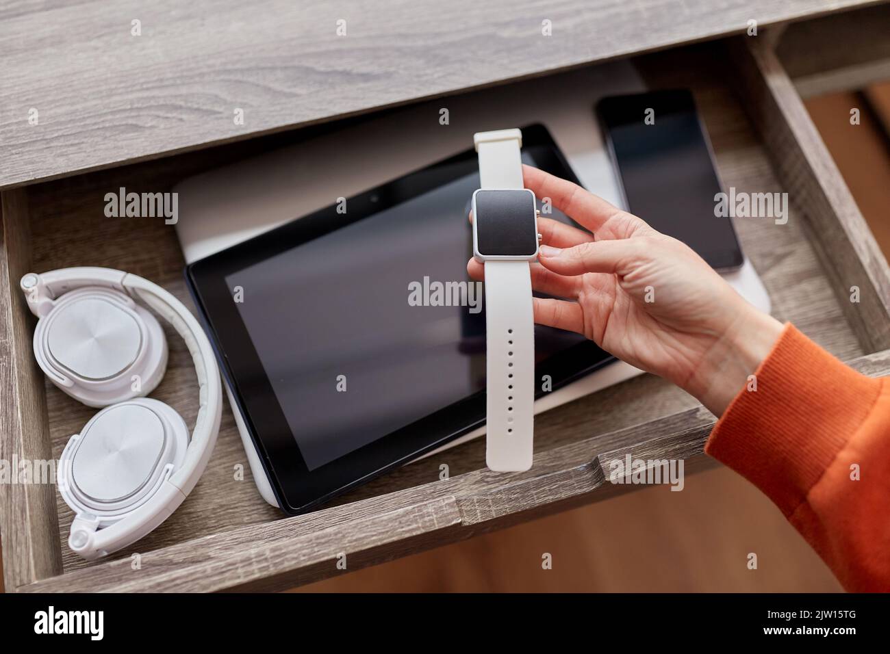 hand with smart watch and gadgets in desk drawer Stock Photo - Alamy