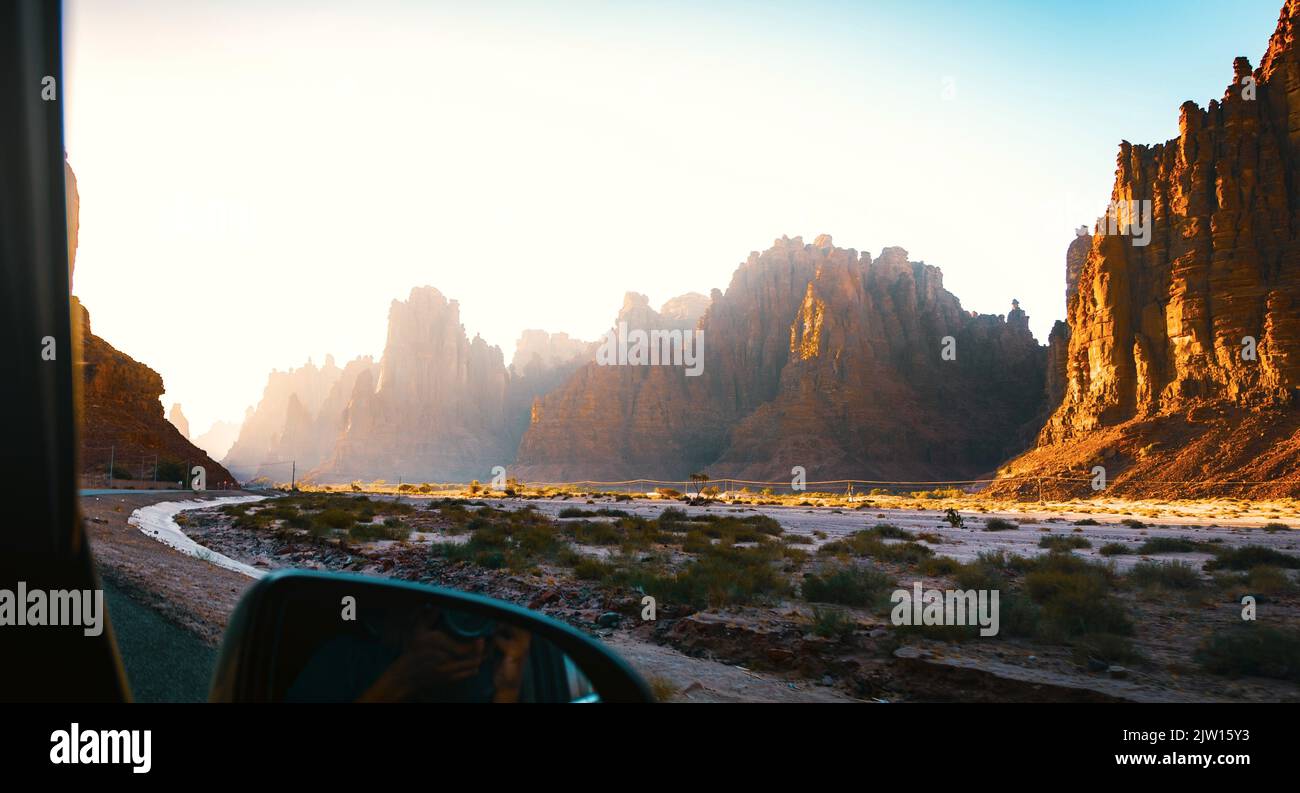 View of a valley through car window at sunrise with huge rock ...