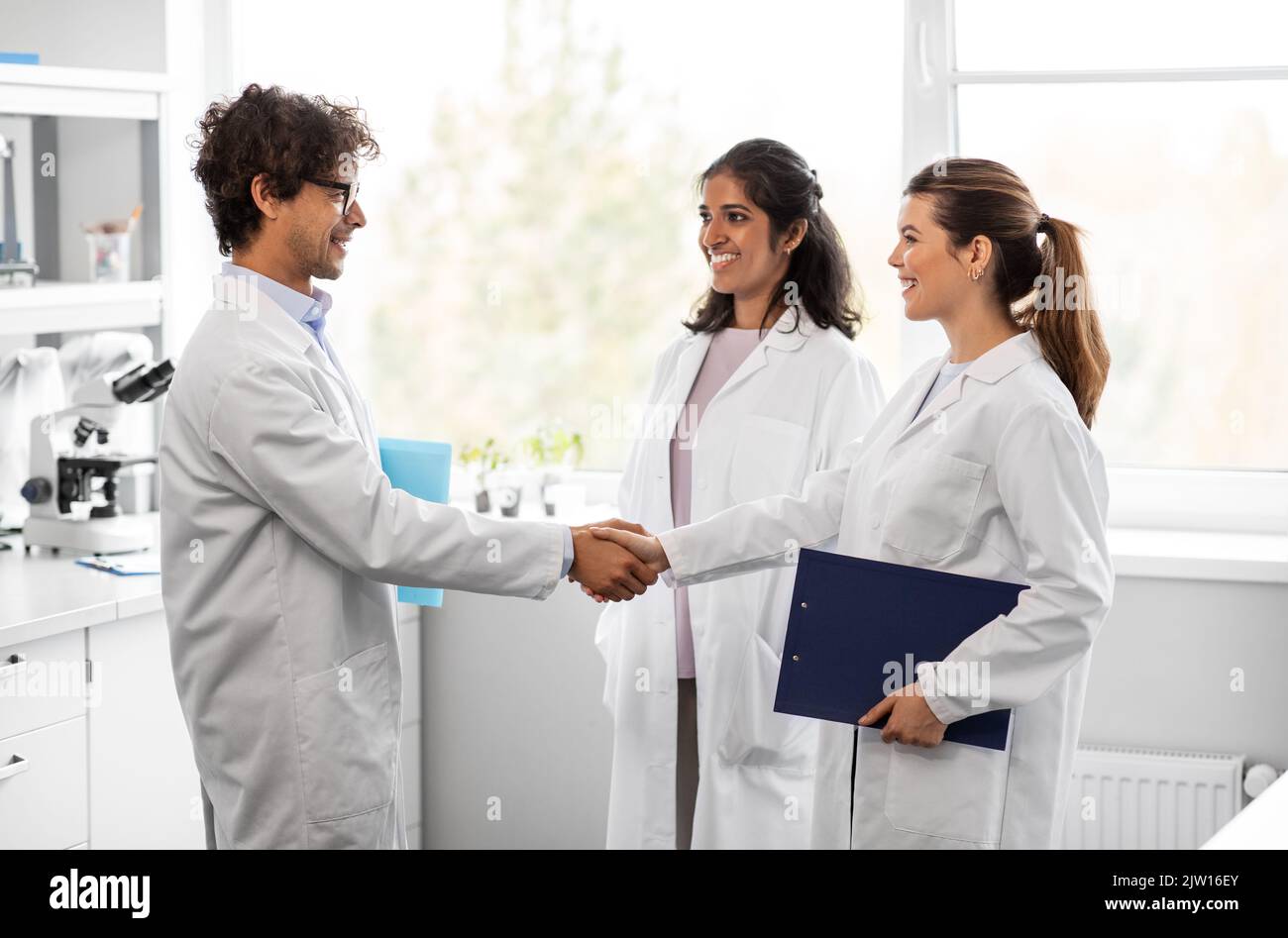 Scientists shaking hands in lab hi-res stock photography and images - Alamy