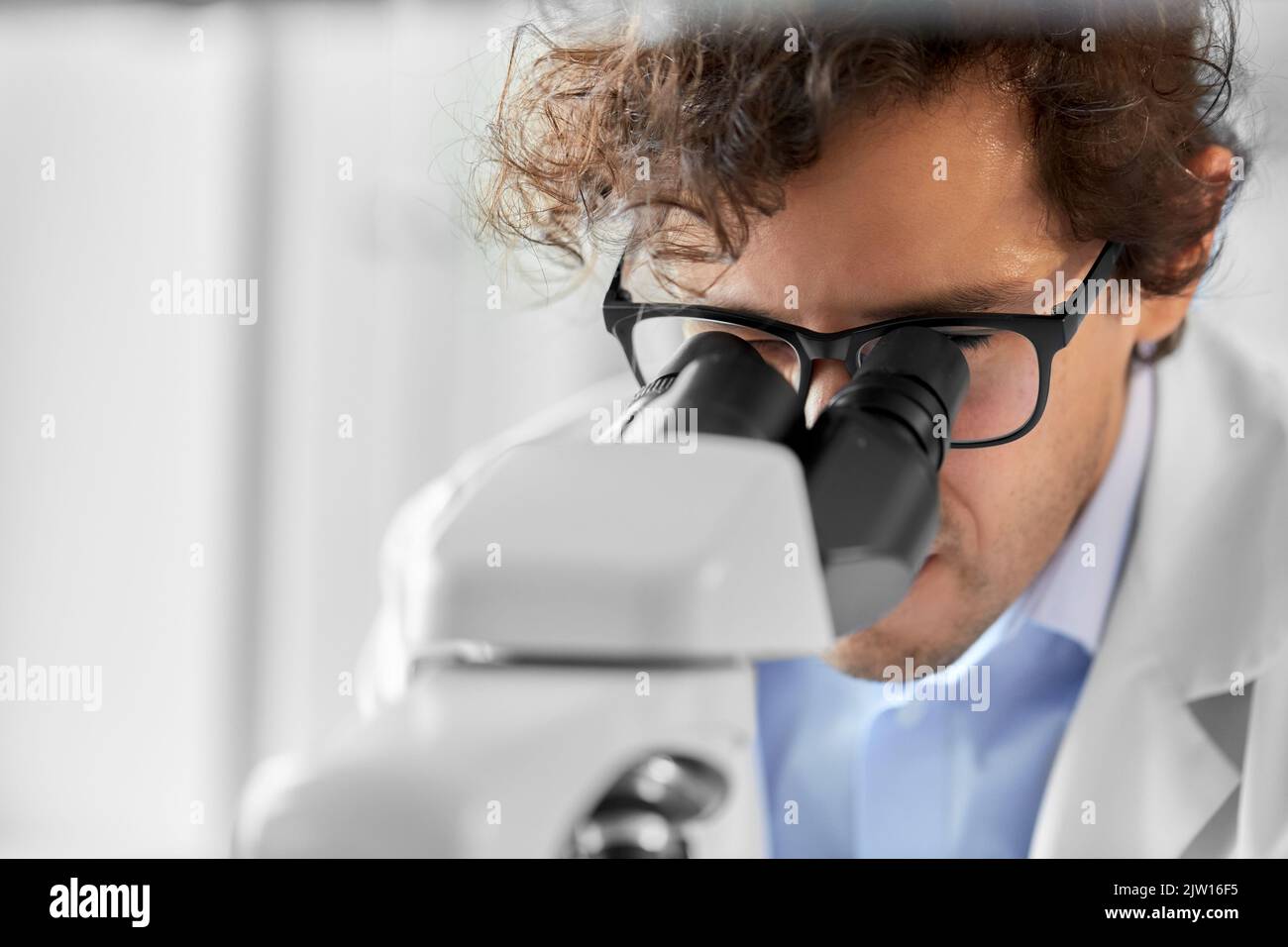 scientist with microscope working in laboratory Stock Photo - Alamy
