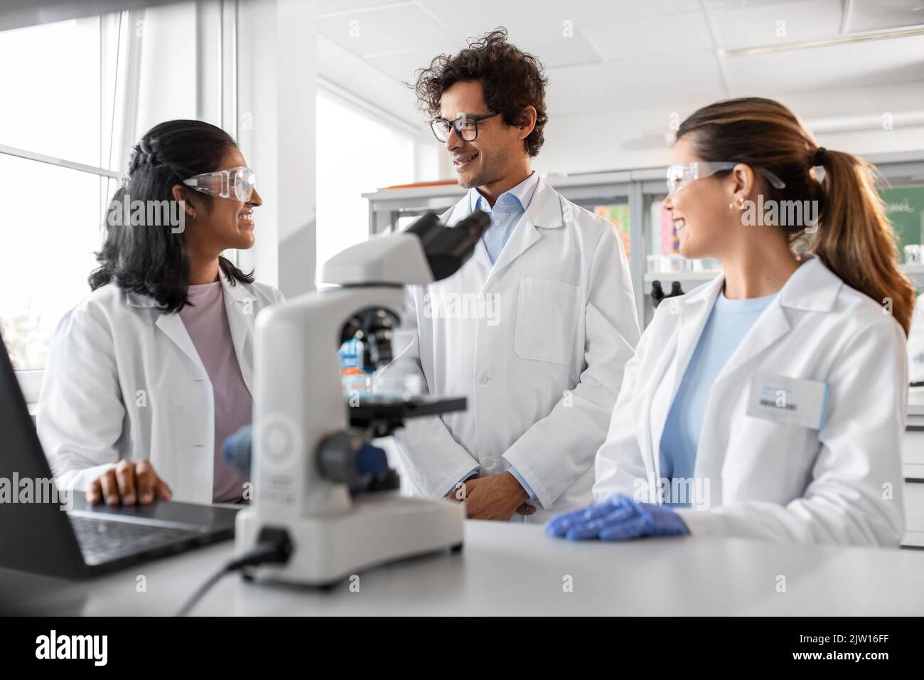 scientists with microscope working in laboratory Stock Photo - Alamy