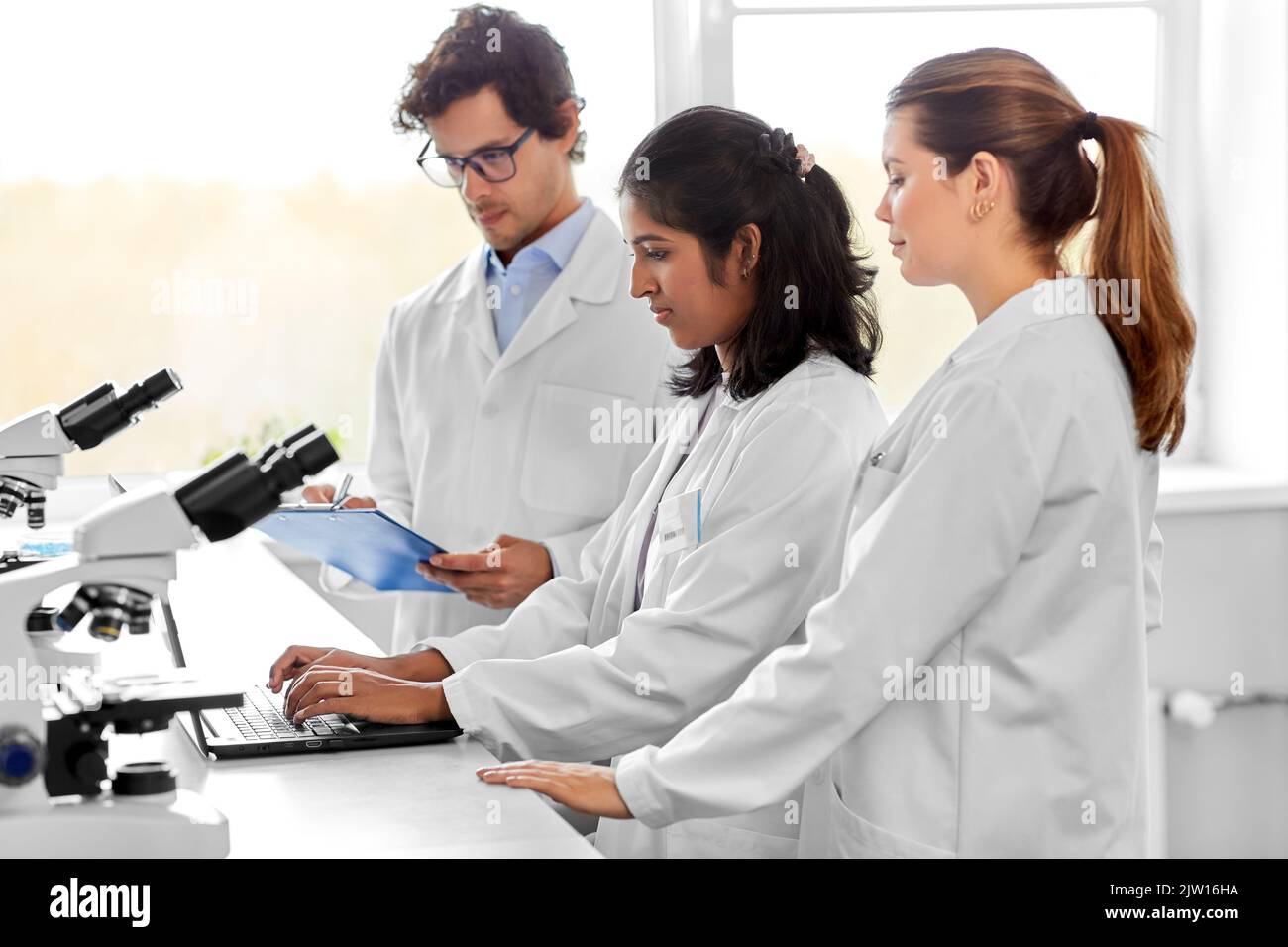 scientists with microscopes working in laboratory Stock Photo - Alamy