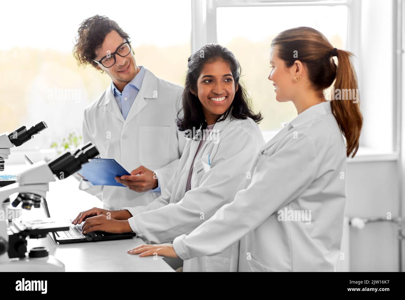 scientists with microscopes working in laboratory Stock Photo - Alamy