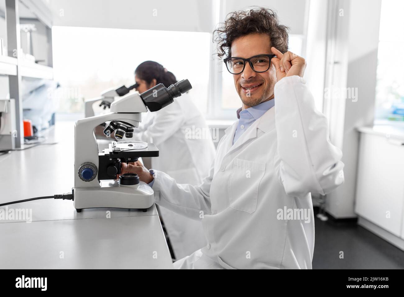 scientist with microscope working in laboratory Stock Photo - Alamy
