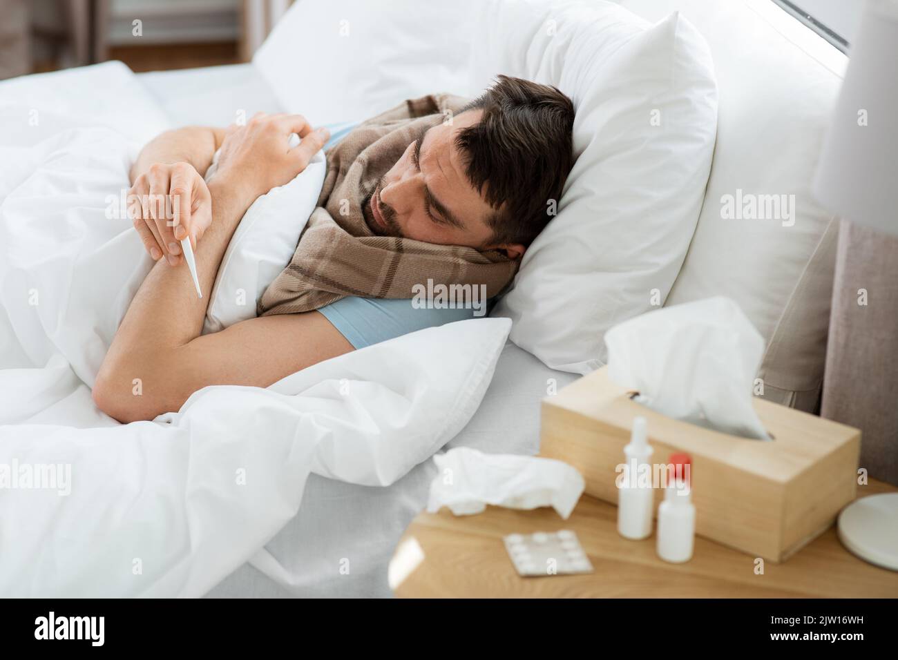 sick man measuring temperature by thermometer Stock Photo - Alamy