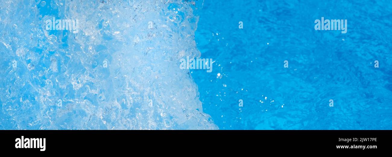 Surface of blue swimming pool water with light reflection, splashes and ...