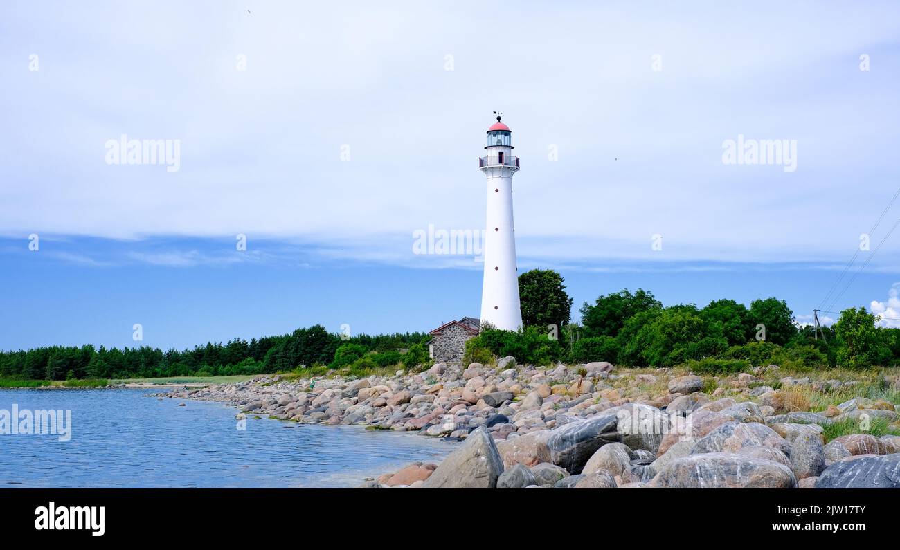 Beautiful lighthouse near the sea in a small village in clear weather ...