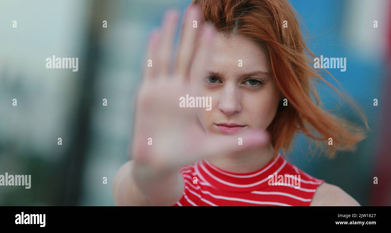 Assertive woman making stop gesture. Strong redhead lady showing hold ...