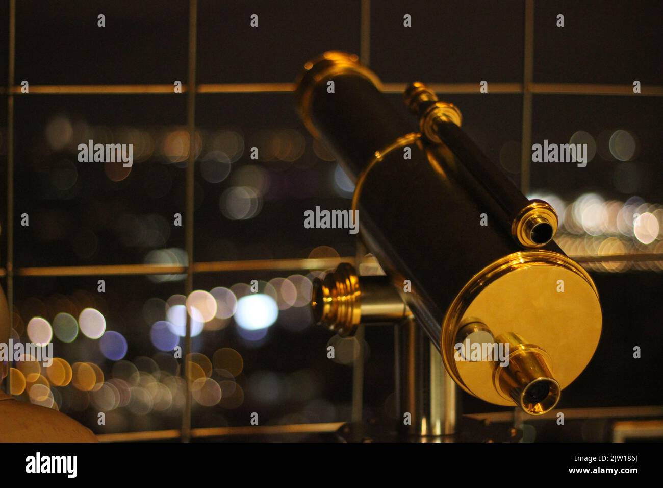 A vintage telescope in front of a window with a view of the starry sky ...