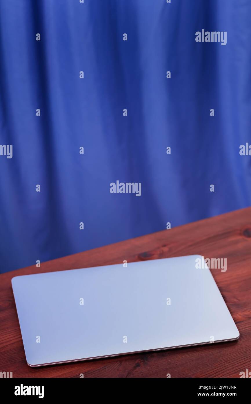 Closed laptop on a wooden table. Silvery laptop at workplace in home ...