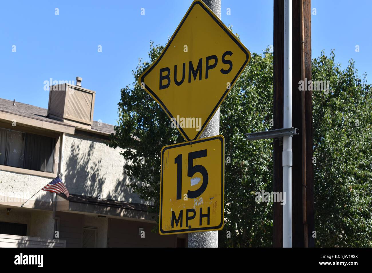 Yellow Bump signs in residential street 15mph Stock Photo - Alamy