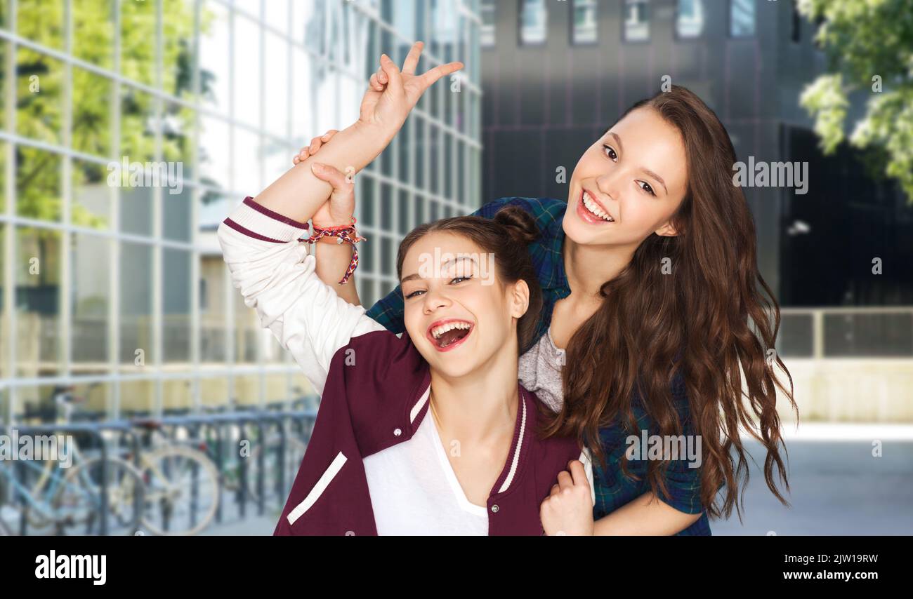 happy teenage girls showing peace on city street Stock Photo - Alamy