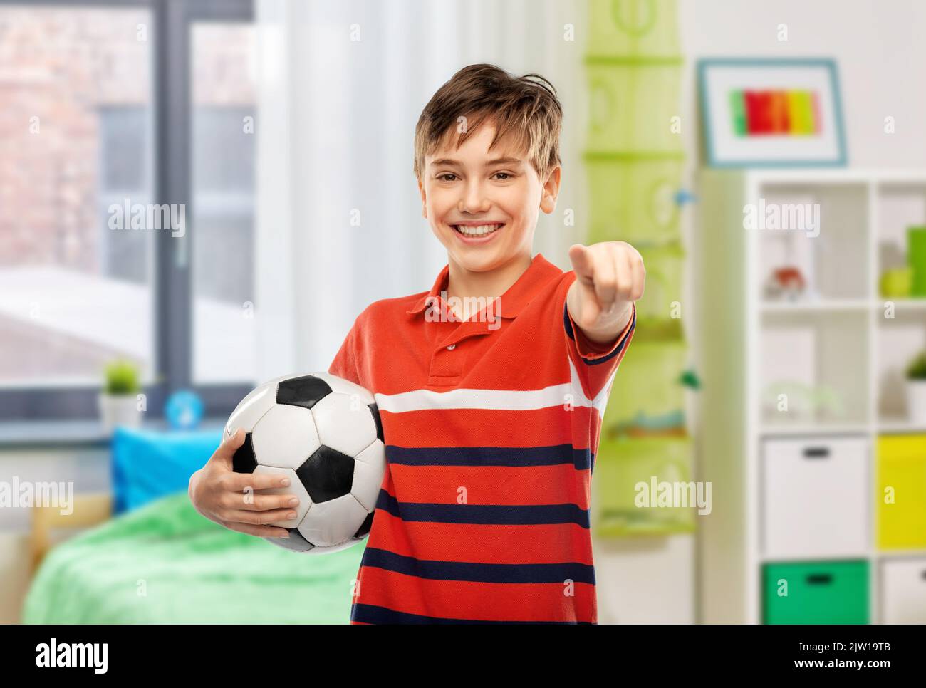 happy boy with soccer ball pointing to you at home Stock Photo - Alamy