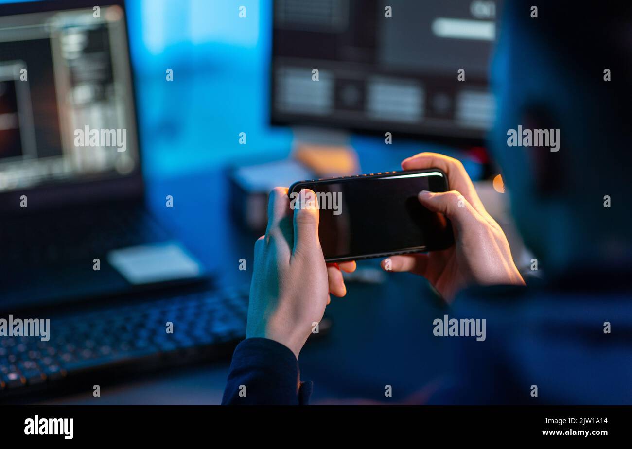 hacker with smartphone and computers in dark room Stock Photo - Alamy