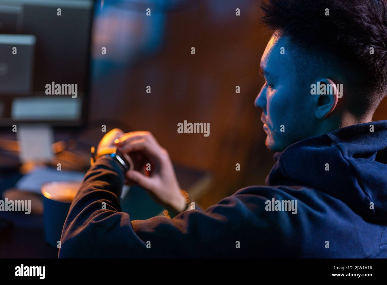 hacker with smart watch and computers in dark room Stock Photo - Alamy