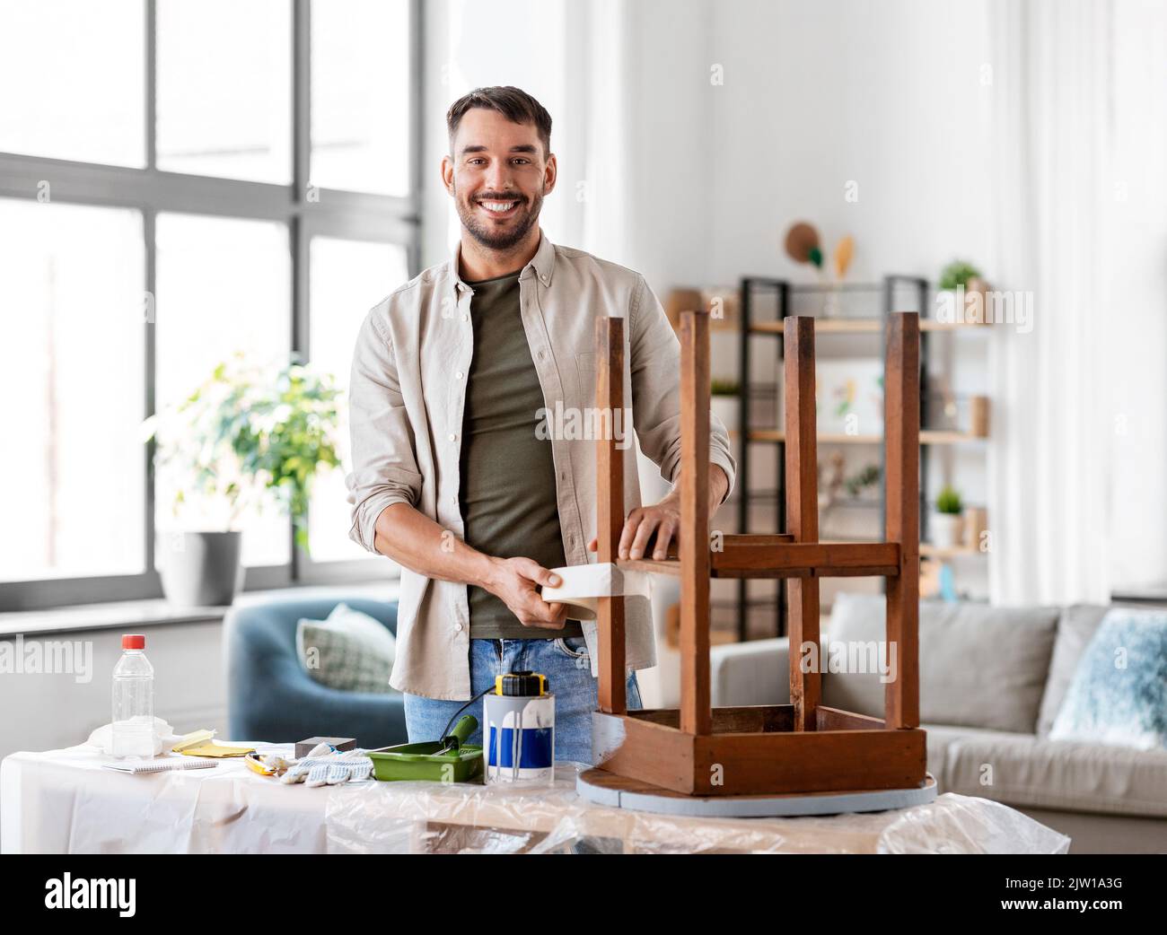 man sticking adhesive tape to table for repainting Stock Photo - Alamy
