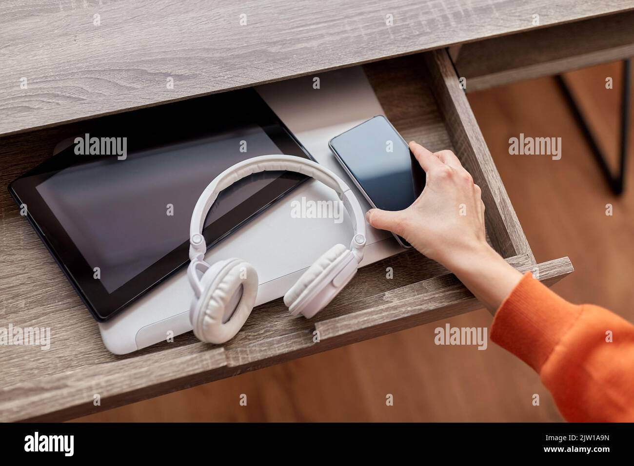 hand with smartphone and gadgets in desk drawer Stock Photo - Alamy