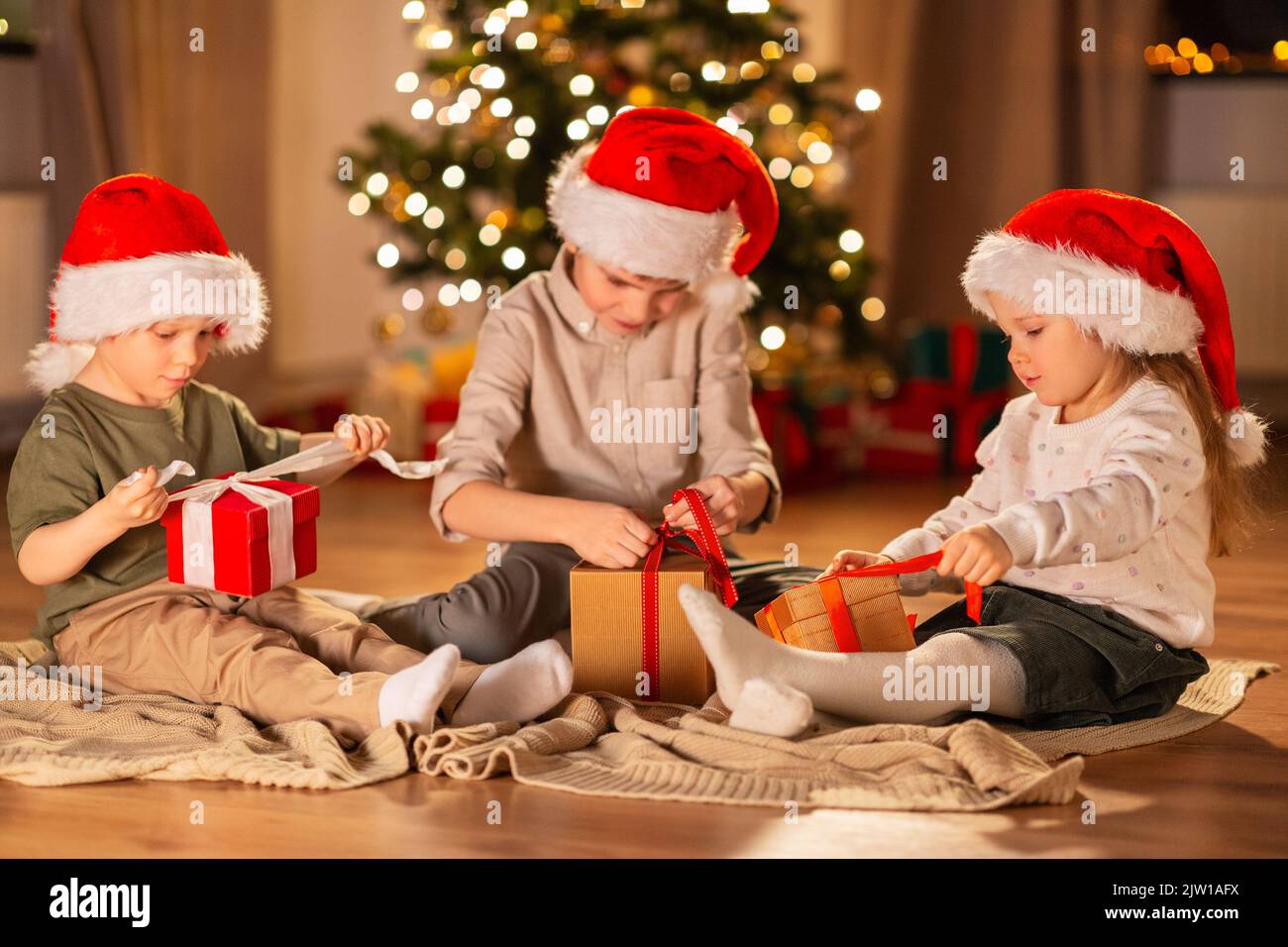happy children opening christmas gifts at home Stock Photo - Alamy