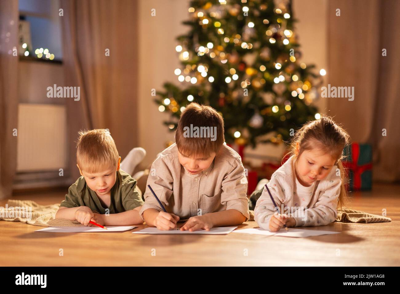 happy children drawing on christmas at home Stock Photo - Alamy
