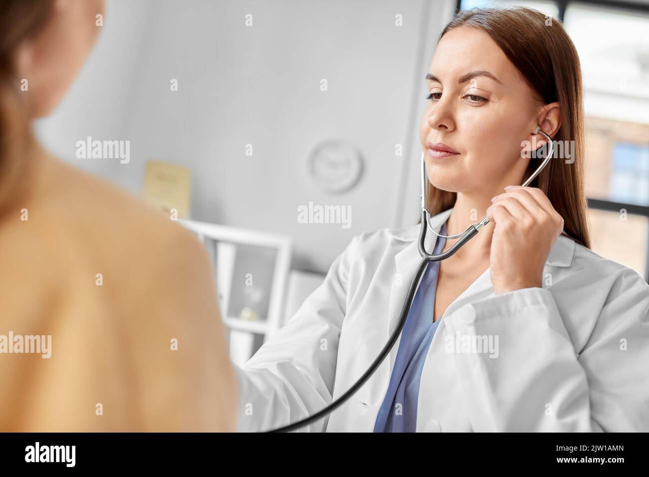 doctor with stethoscope and woman at hospital Stock Photo - Alamy