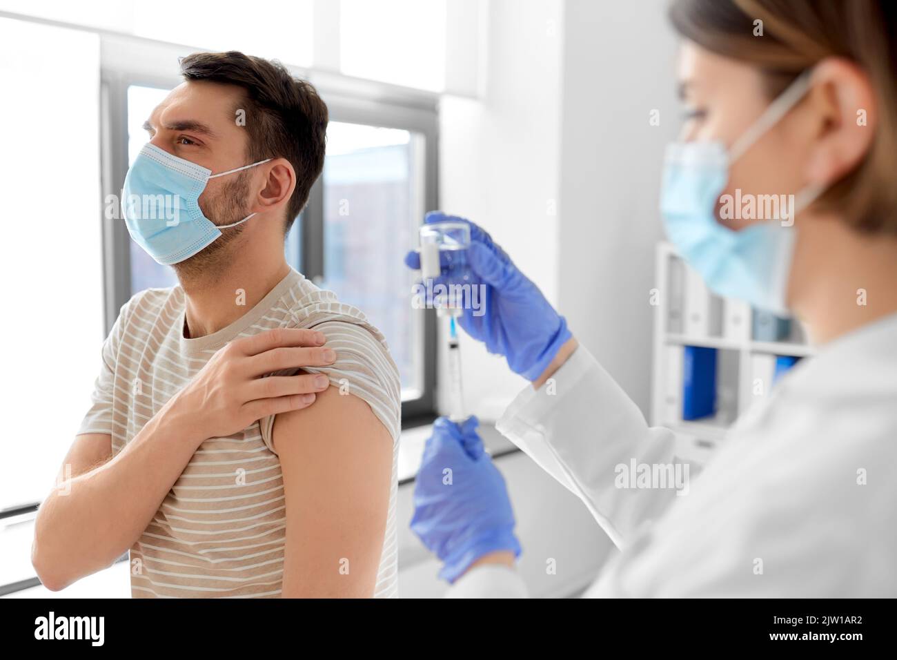 doctor with syringe vaccinating male patient Stock Photo - Alamy