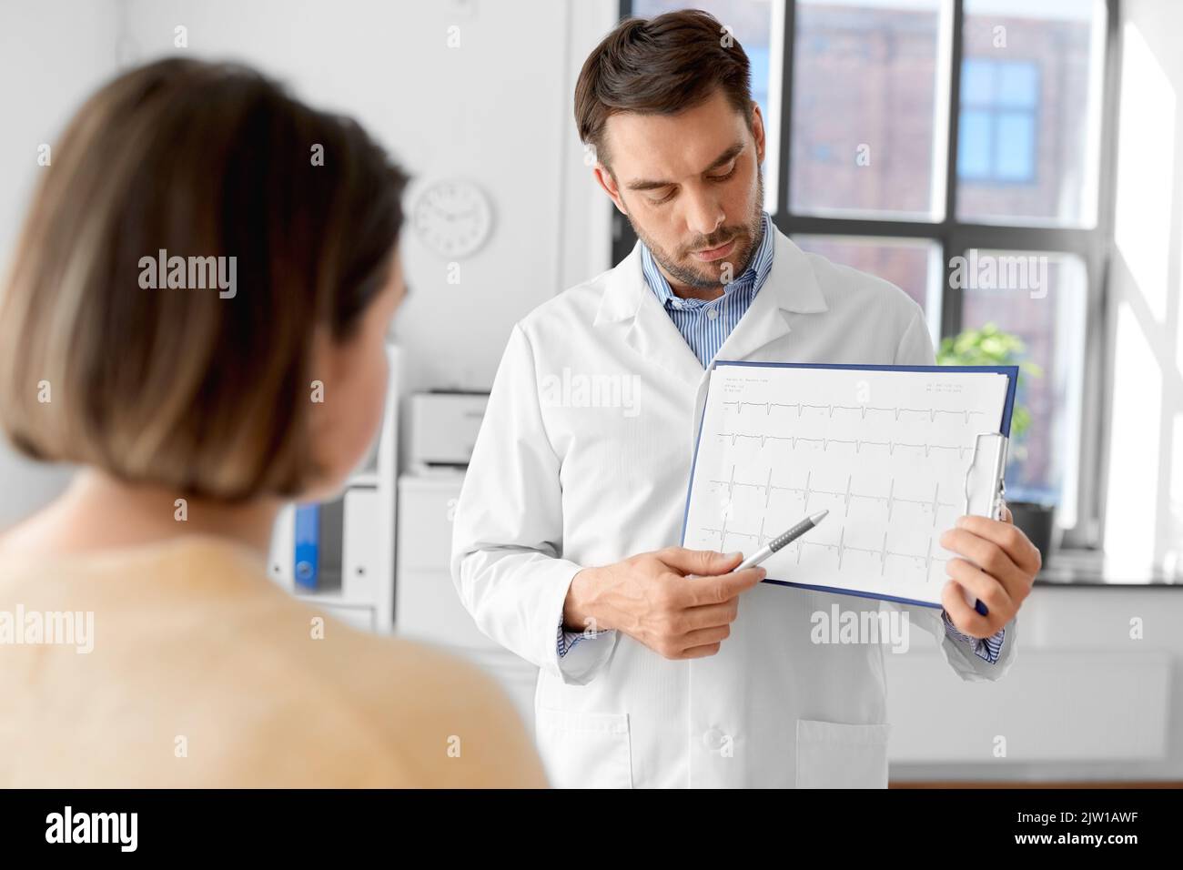 doctor showing cardiogram to woman at hospital Stock Photo - Alamy