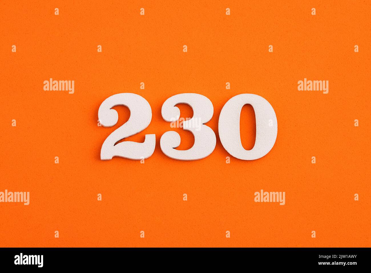 White wooden number 230 on eva rubber orange background Stock Photo - Alamy