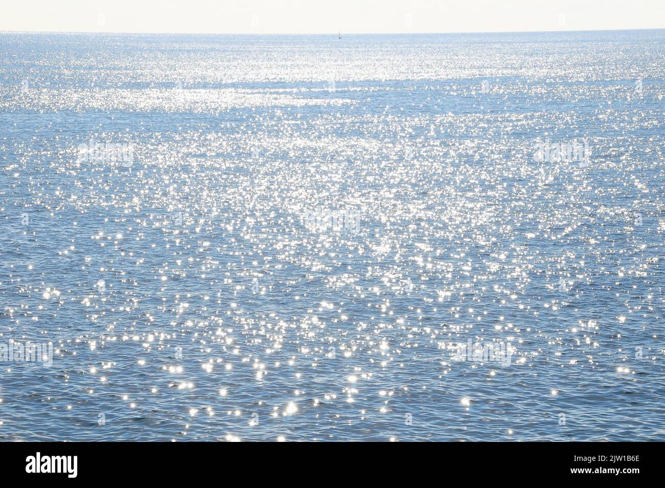 A blue sea water texture with sunlight reflecting on the surface ...