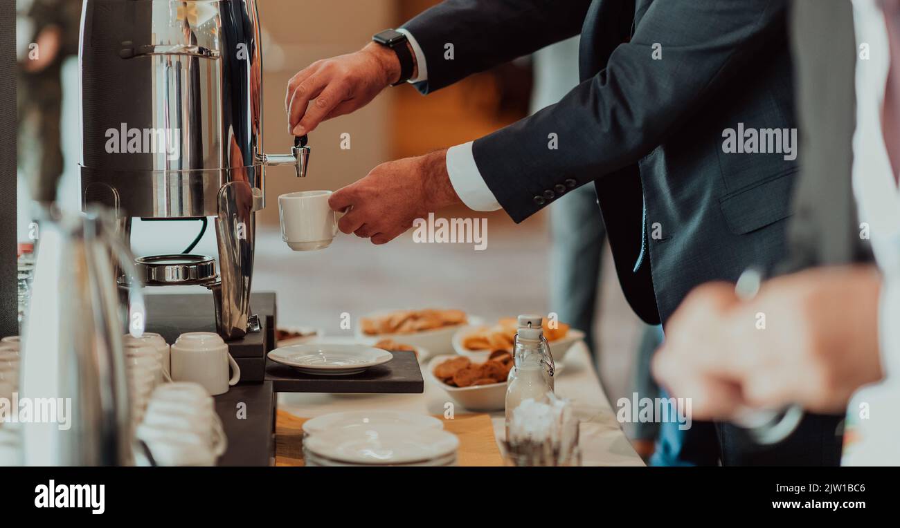 Close-up photo of businessmen serving themselves in a modern hotel ...