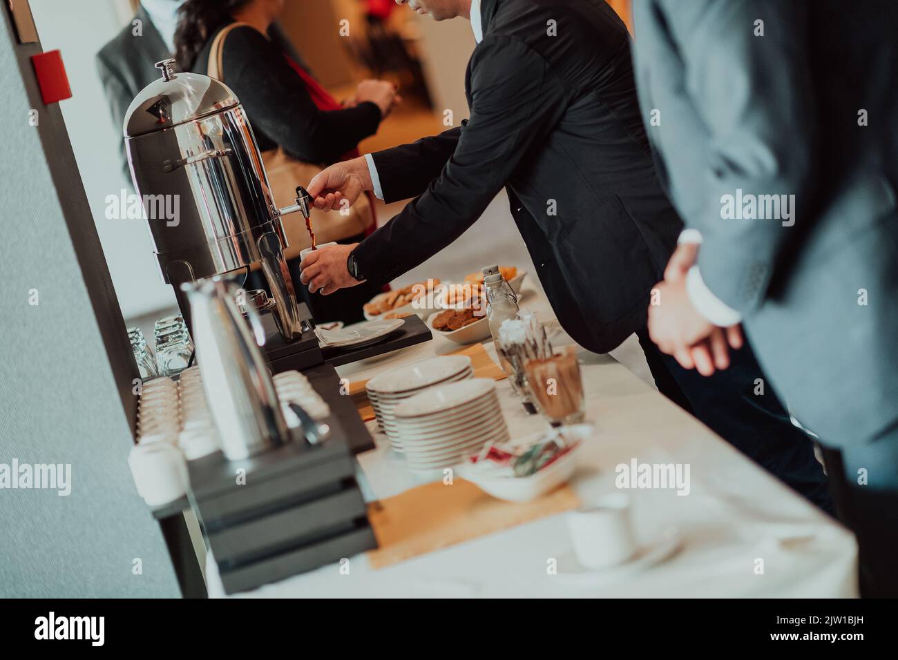 Close-up photo of businessmen serving themselves in a modern hotel ...