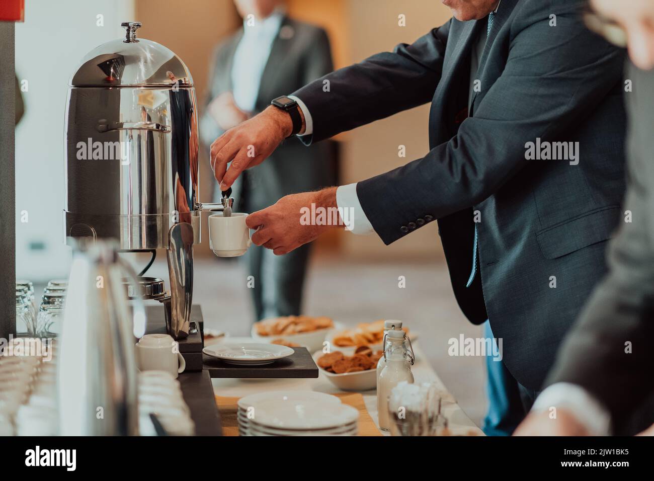Close-up photo of businessmen serving themselves in a modern hotel ...