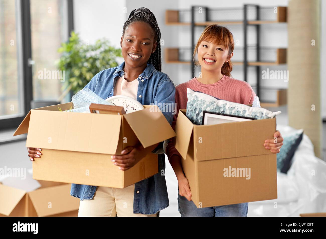 women with boxes moving to new home Stock Photo - Alamy