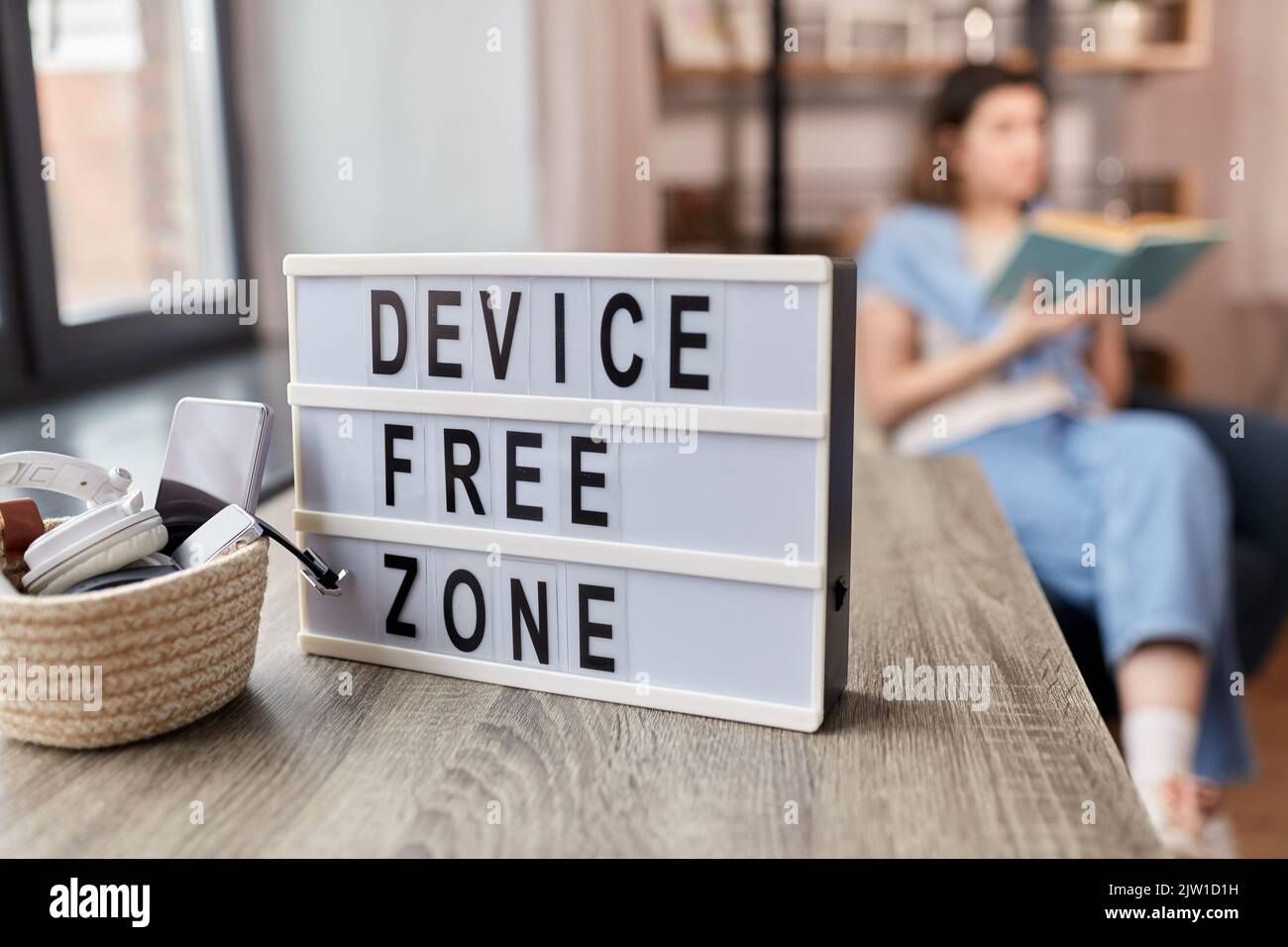 gadgets at device free zone and woman reading book Stock Photo - Alamy