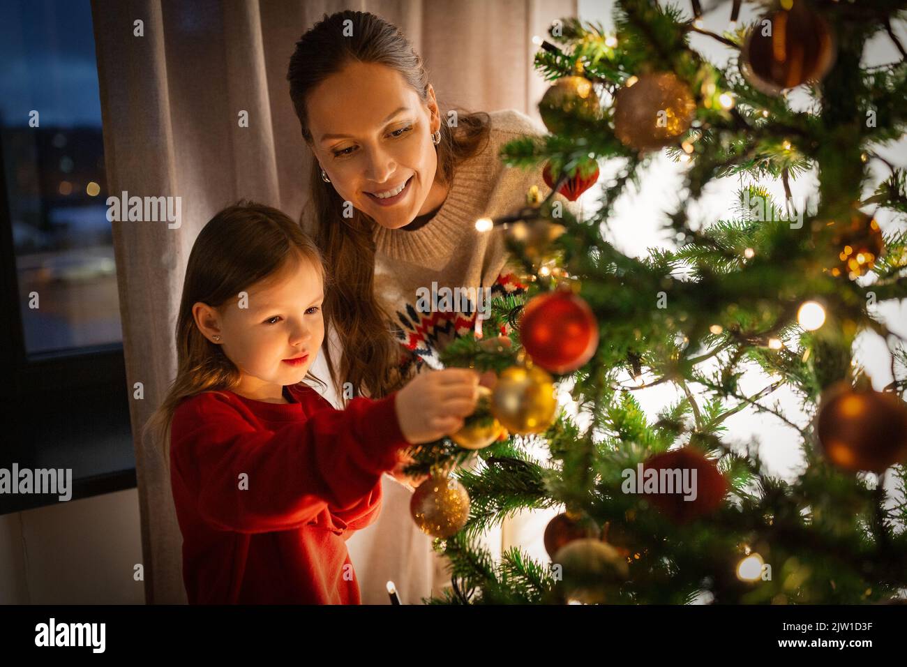 happy family decorating christmas tree at home Stock Photo - Alamy