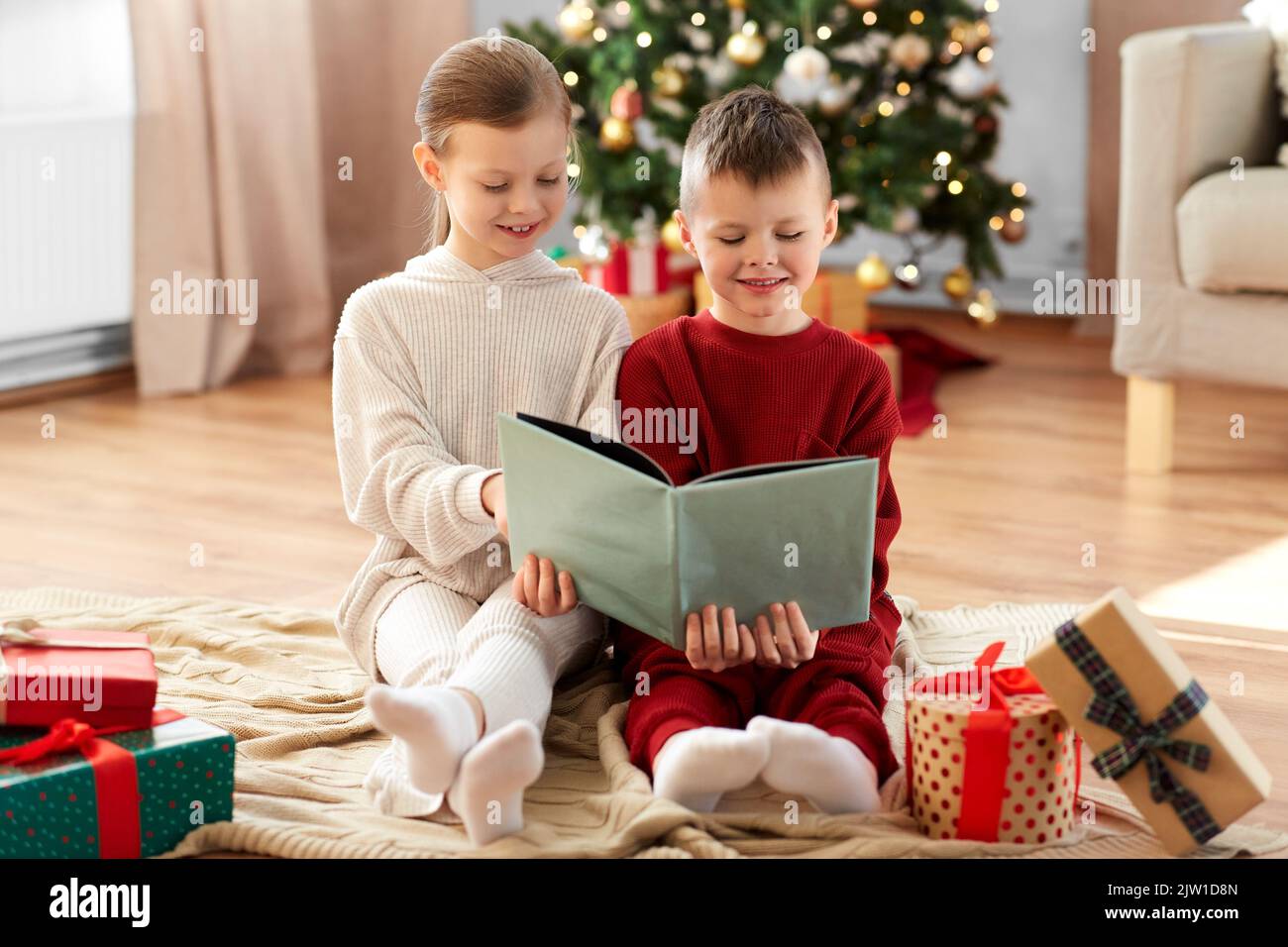 happy children reading book on christmas at home Stock Photo - Alamy