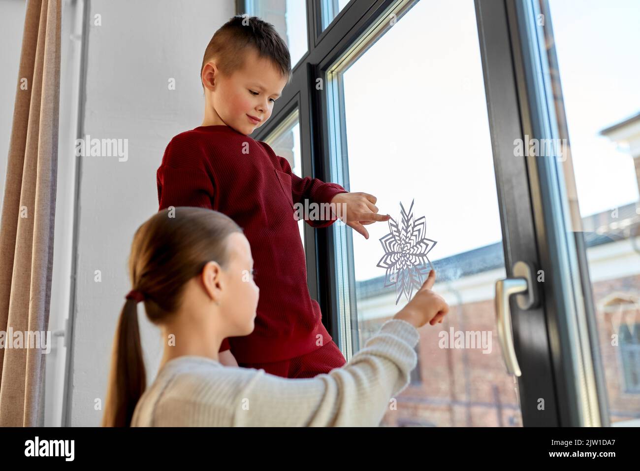 happy children decorating window on christmas Stock Photo - Alamy