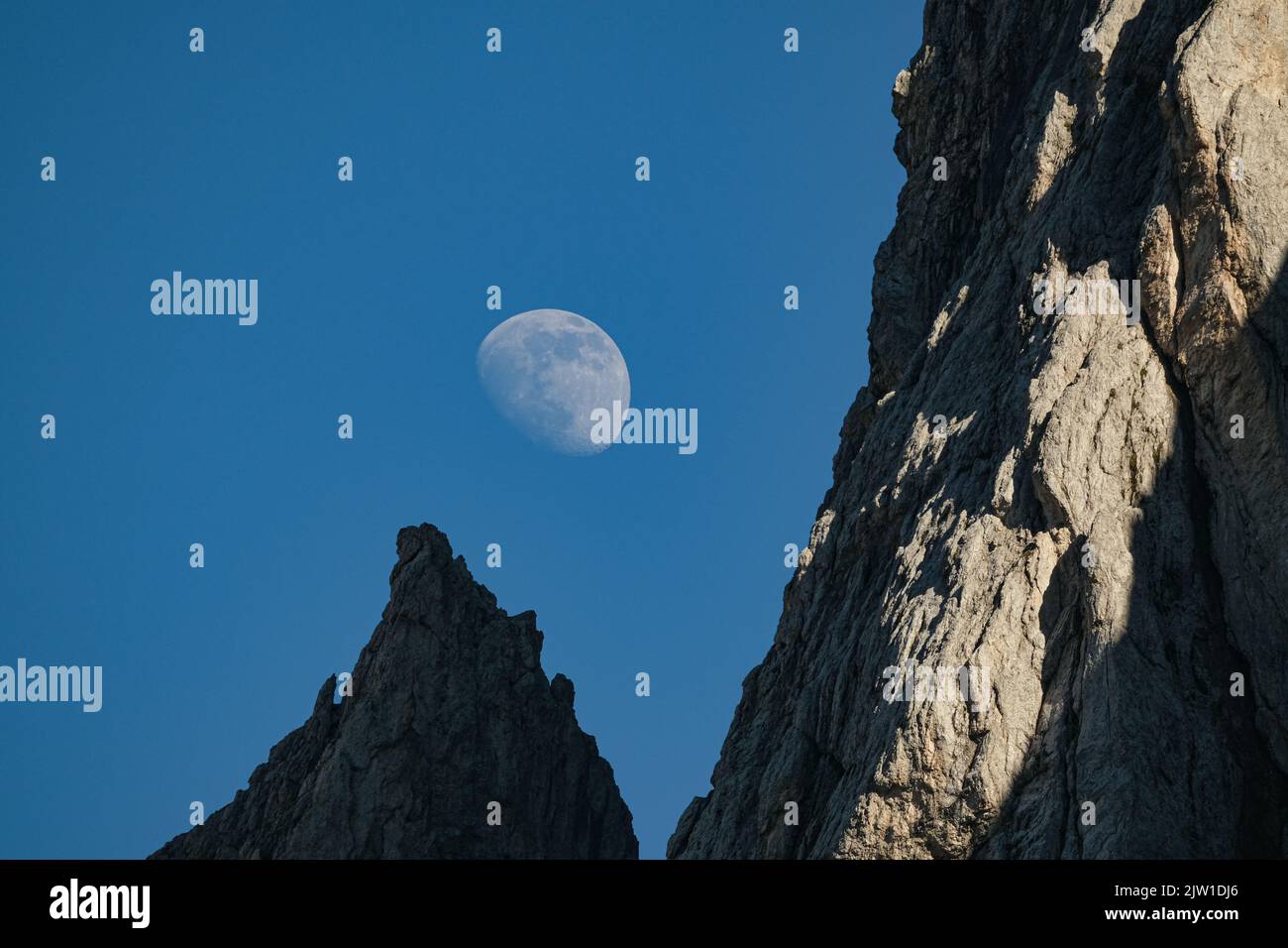 A rocky cliff with the fading moon in the background Stock Photo - Alamy